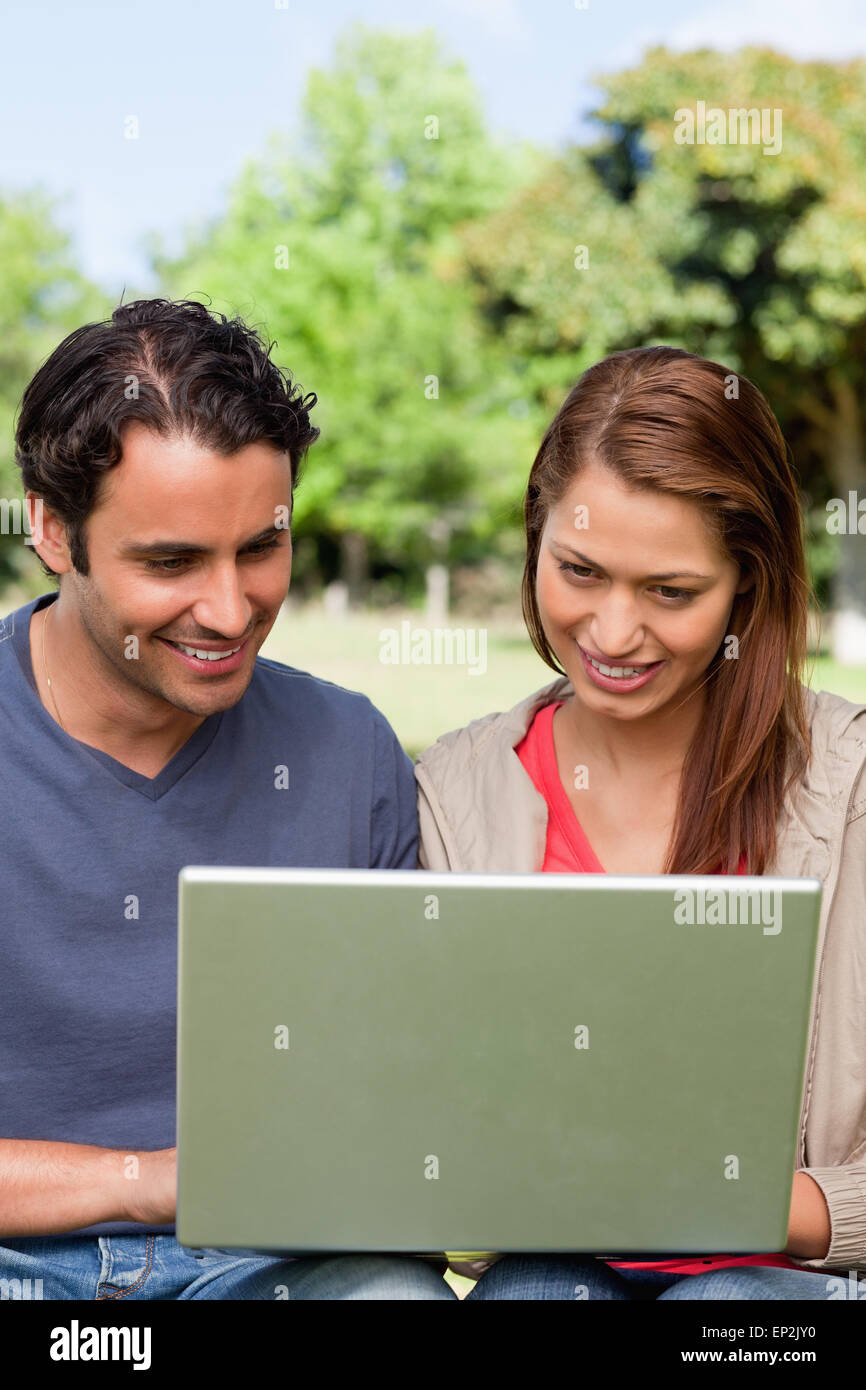 Two friends smiling as they watch something on a tablet Stock Photo - Alamy