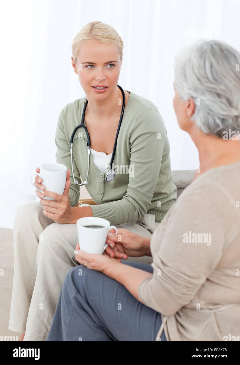 Doctor drinking with her patient Stock Photo - Alamy