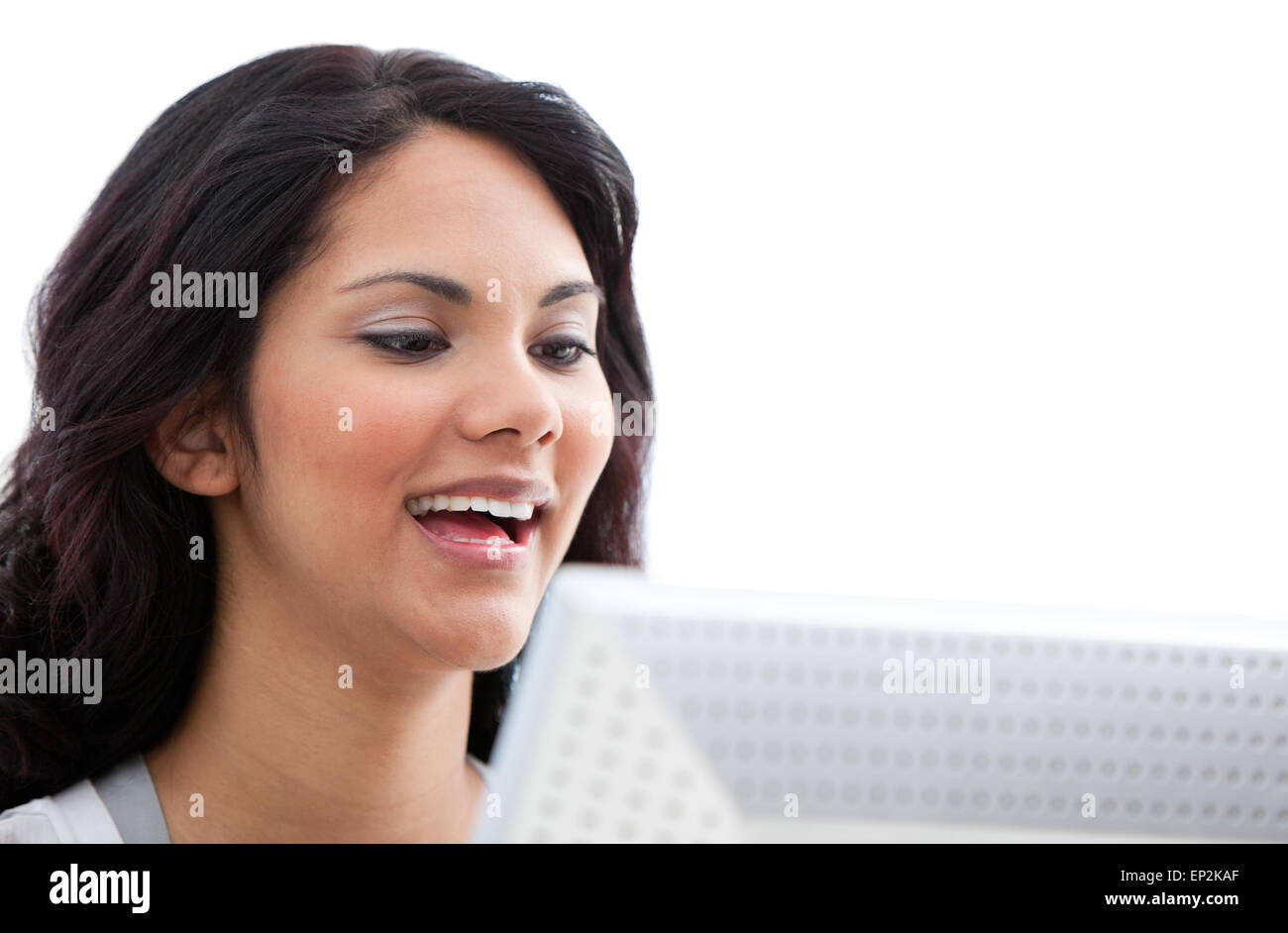 Radiant businesswoman working at a computer against a white background ...
