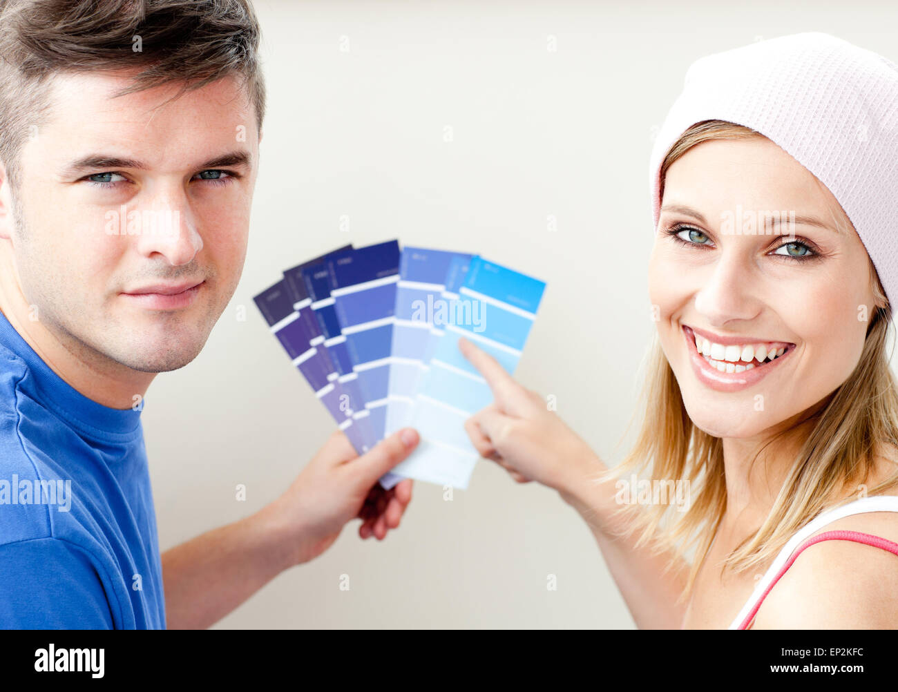 Cheerful couple with color samples for painting a room in their new ...