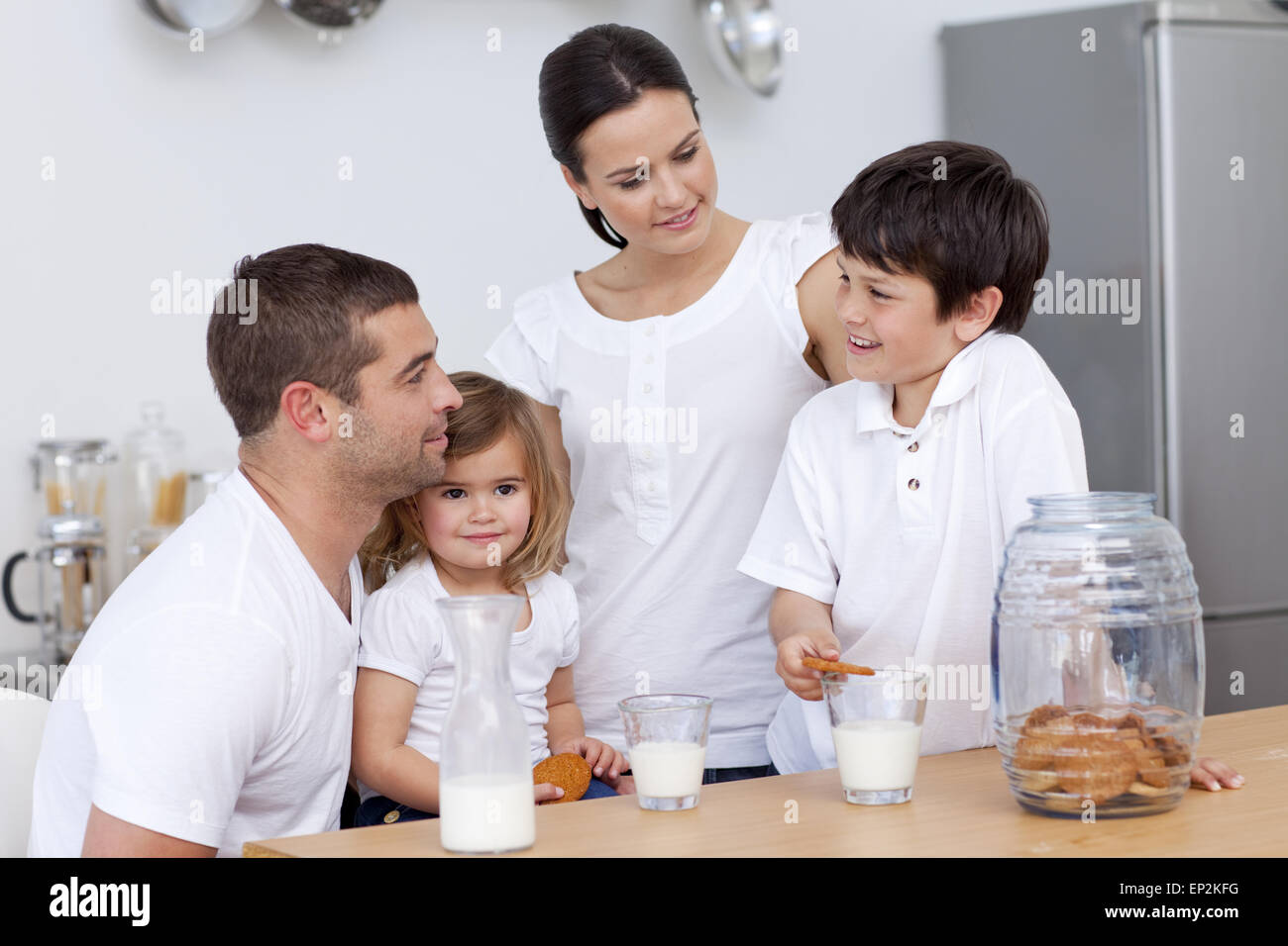 Parents and children eating biscuits and drinking milk Stock Photo - Alamy