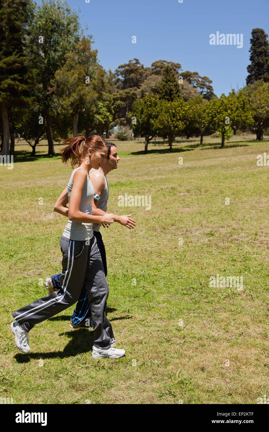 Two friends jogging along side each other across grass Stock Photo - Alamy