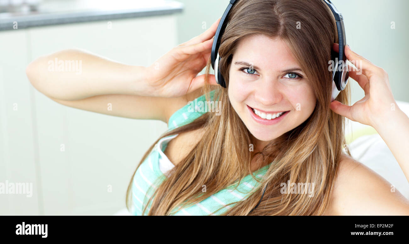Charming caucasian girl listening to music sitting on a sofa Stock ...