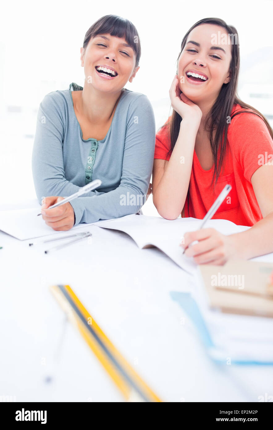 A pair of girls laughing as they look at the camera Stock Photo - Alamy