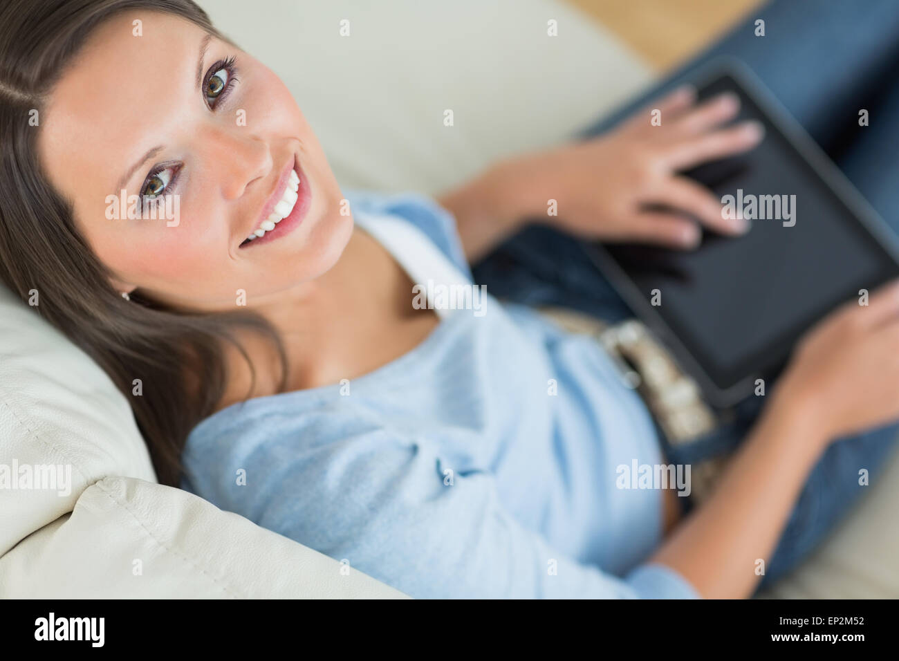 Woman sitting on the sofa and using a digital tablet Stock Photo - Alamy