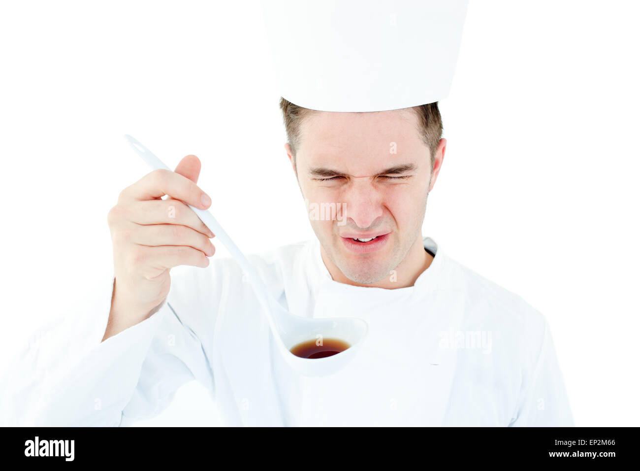 Young male chef tasting a soup with distorted face against white ...