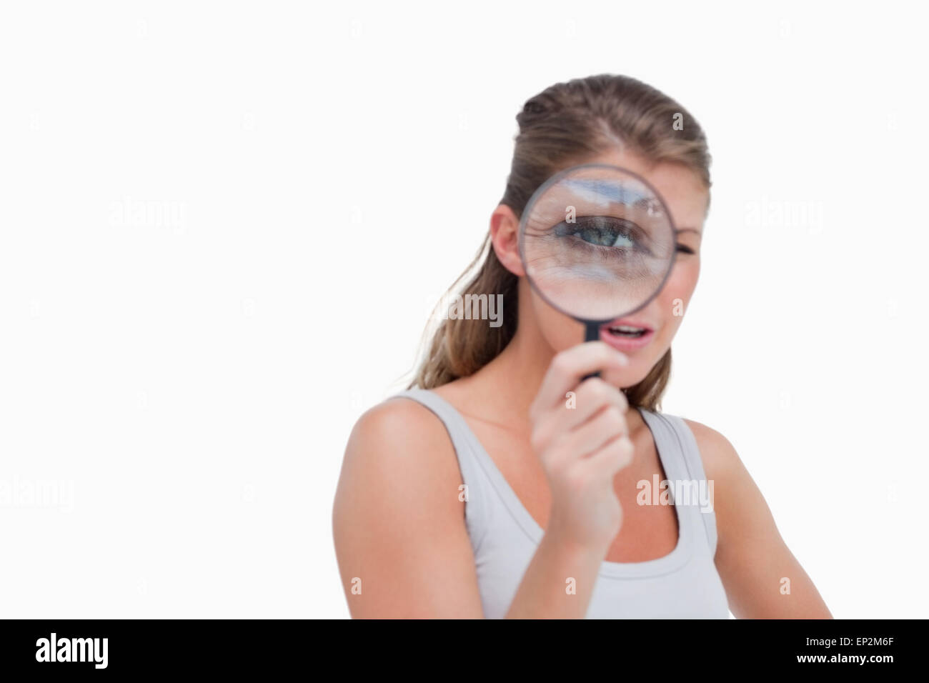Young woman looking through a magnifying glass Stock Photo - Alamy