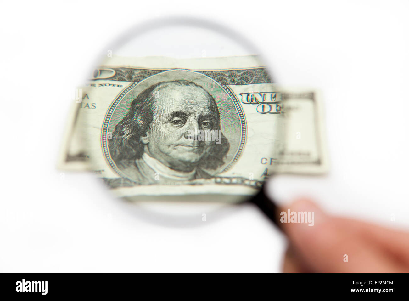 Hand holding magnifying glass over dollar bill Stock Photo - Alamy