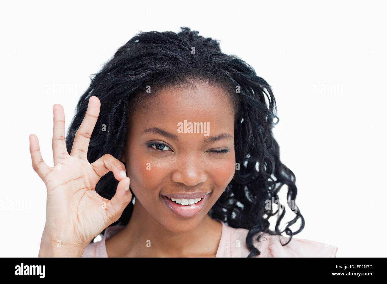 A young woman winking and holding her hand in the okey sign Stock Photo ...