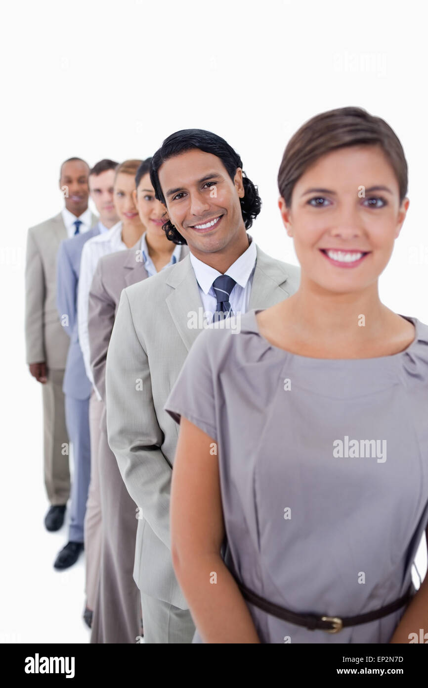 Close-up of co-workers in a single line smiling and looking straight ...
