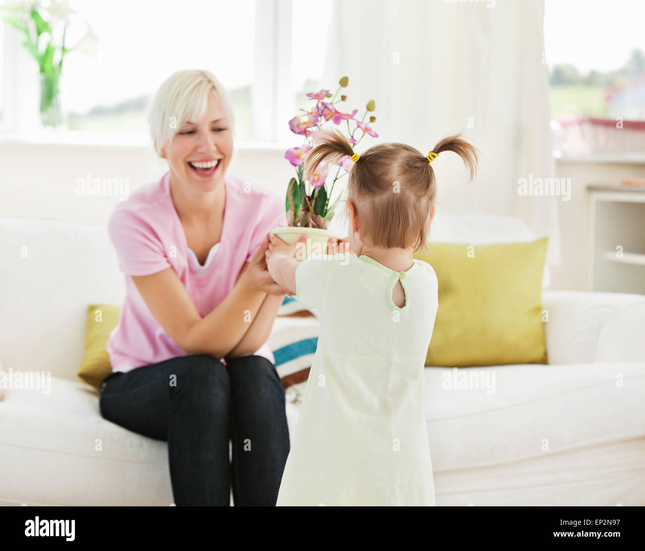 Smiling woman get surprise by her daughter Stock Photo - Alamy