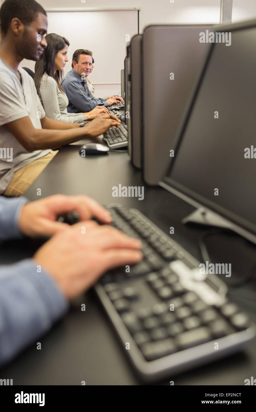Mature student looking up from computer class Stock Photo - Alamy