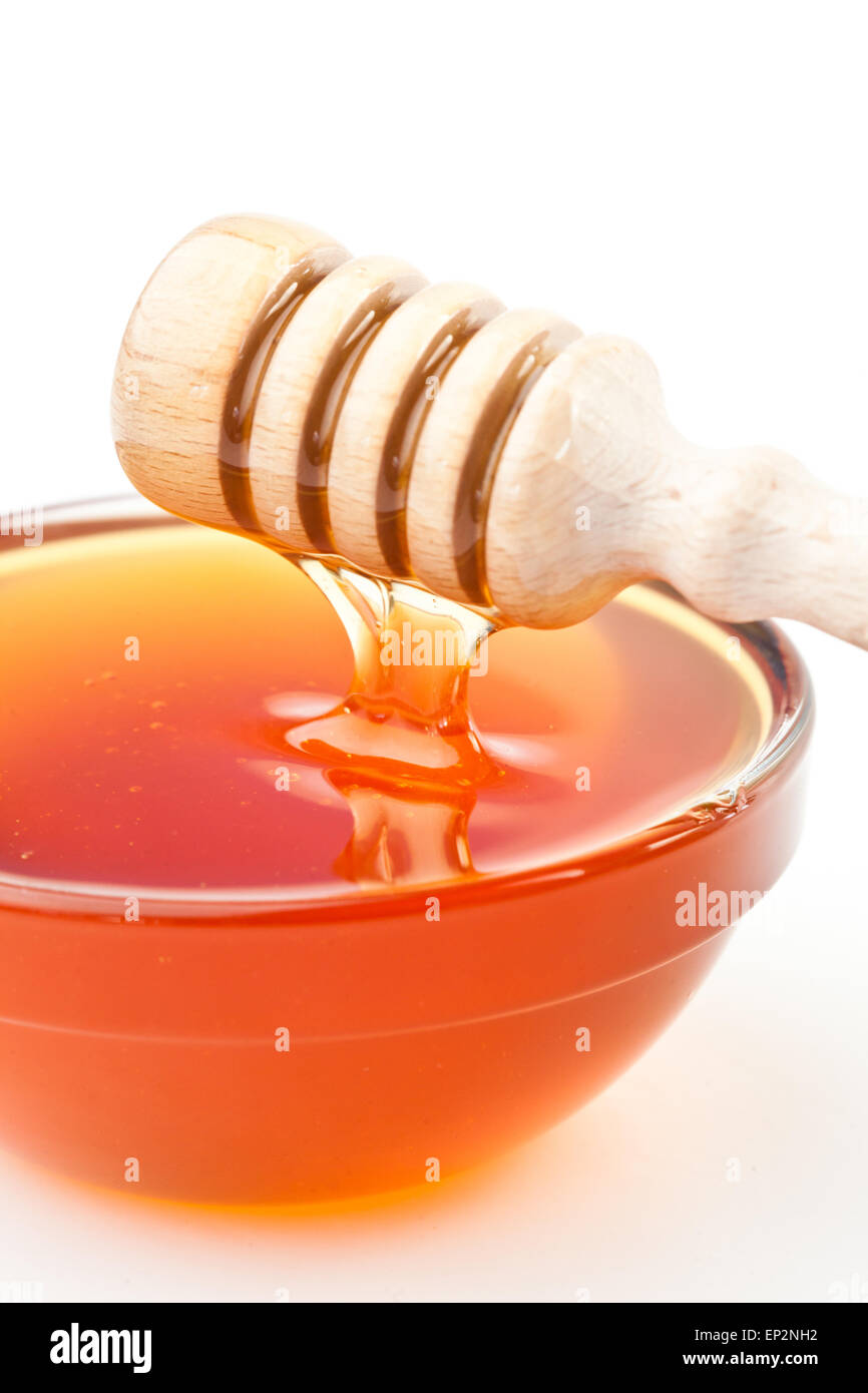 Honey sticky trickle dropping in a honey bowl Stock Photo - Alamy