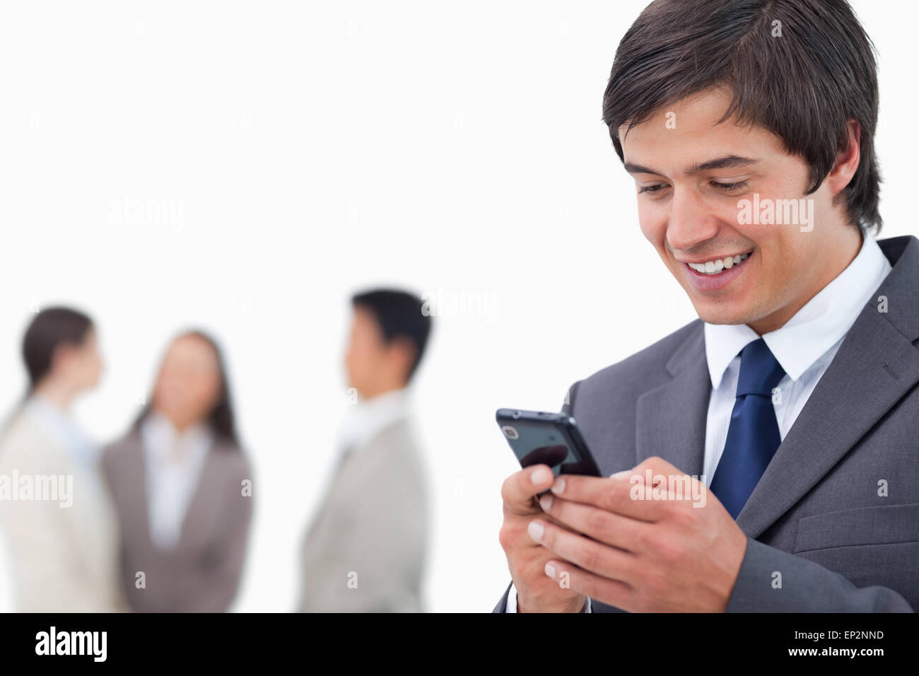 Salesman writing text message with team behind him Stock Photo - Alamy
