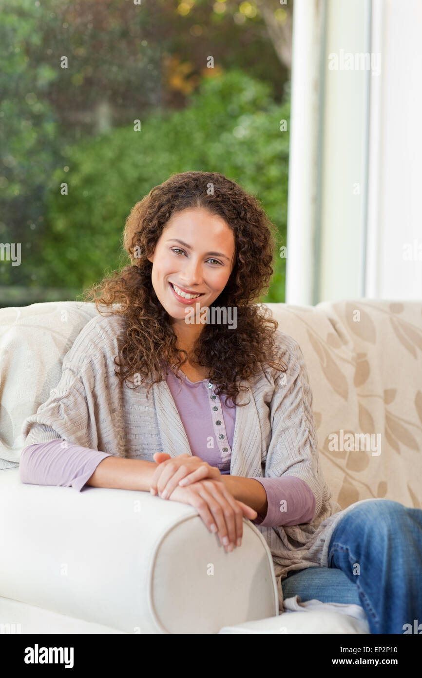 Smiling woman sitting on her sofa Stock Photo - Alamy