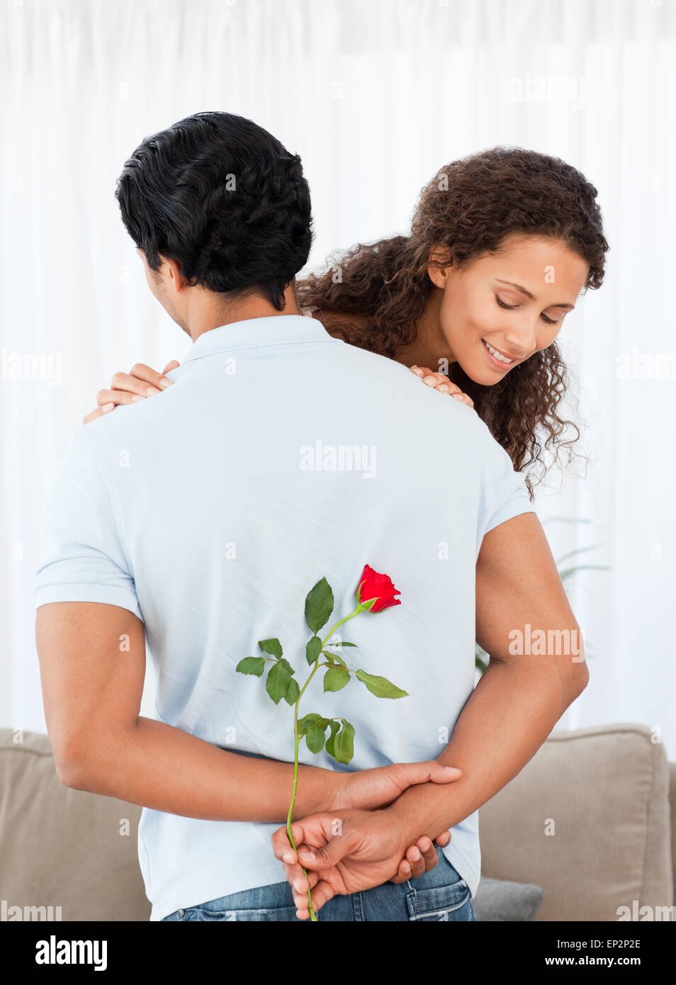 Beautiful woman finding a rose hidden by his boyfriend Stock Photo - Alamy