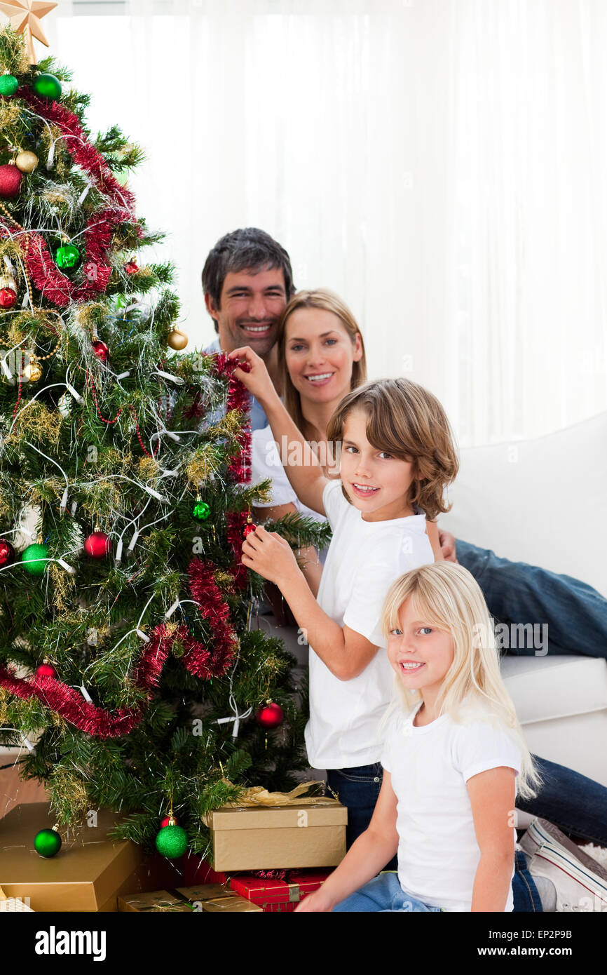 Parents and their children decorating a Christmas tree Stock Photo - Alamy