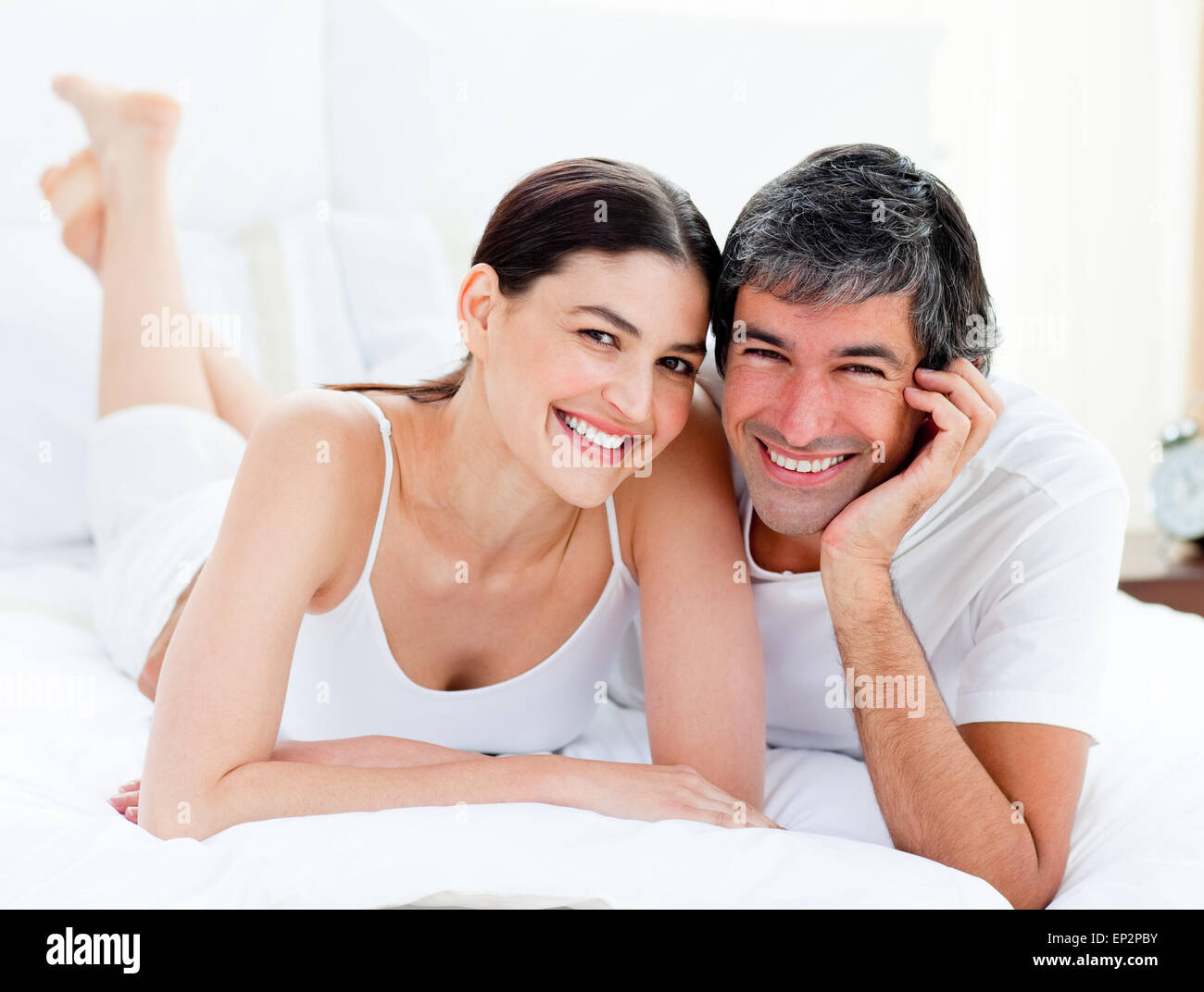 Enamored couple embracing lying on their bed Stock Photo - Alamy