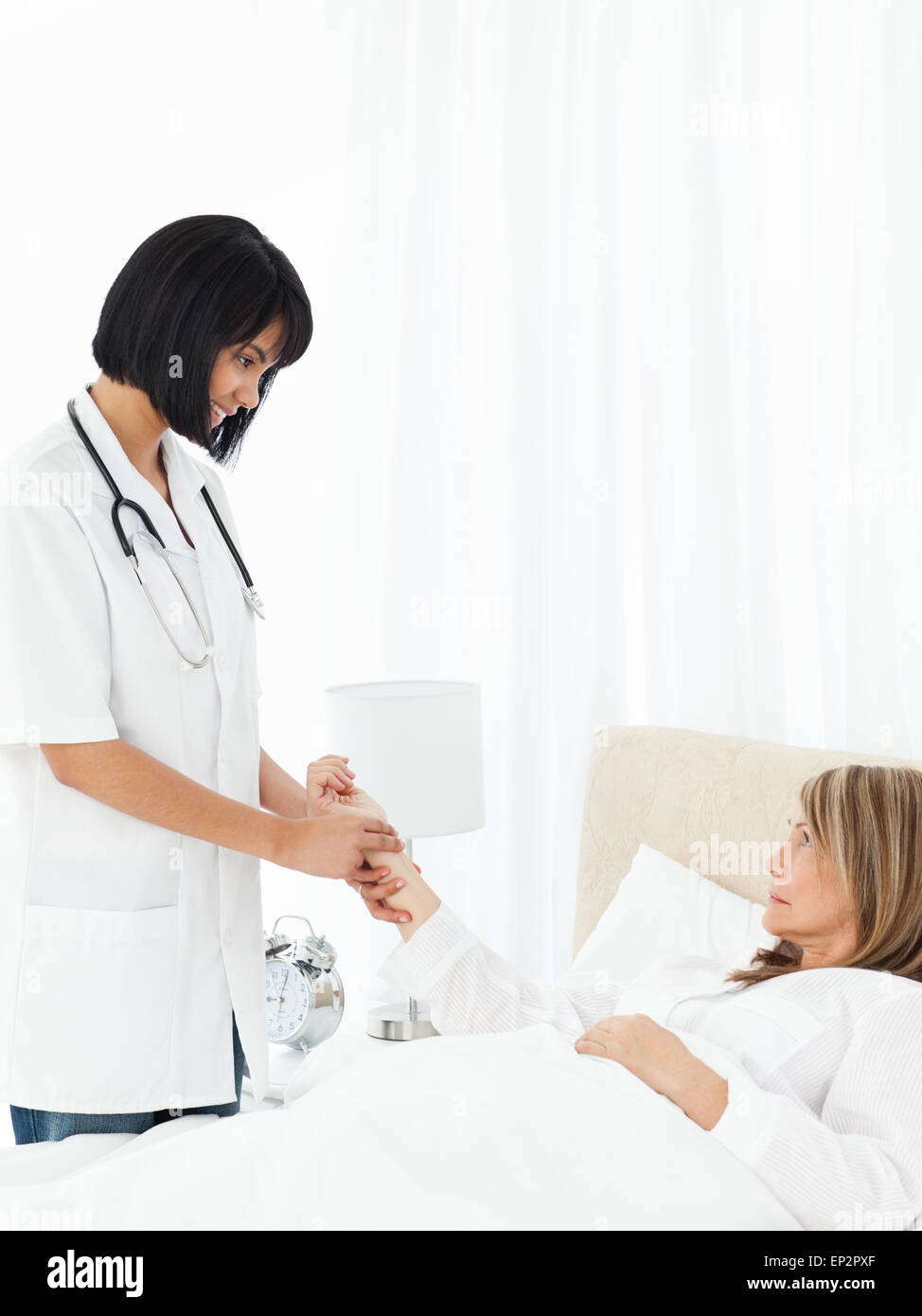 Nurse taking the pulse of her patient Stock Photo - Alamy