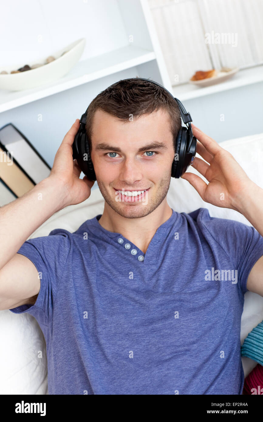 Relaxed young man listening to music looking at the camera Stock Photo ...