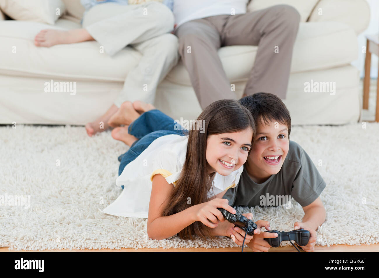 Children playing videogames while parents are talking Stock Photo - Alamy