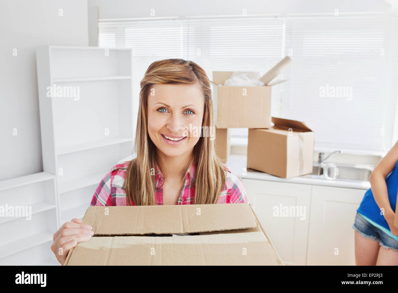 Bright woman carrying boxes at home Stock Photo - Alamy