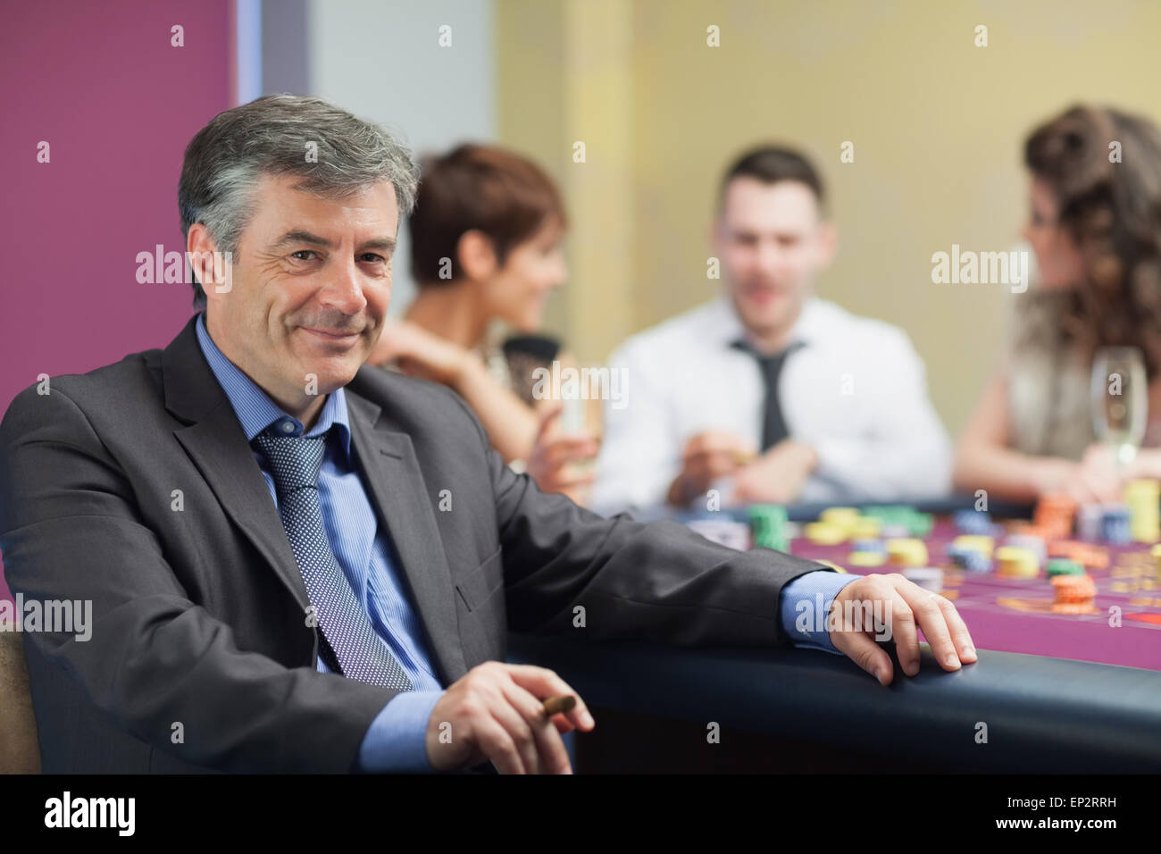 Man with cigar taking break from roulette table Stock Photo - Alamy