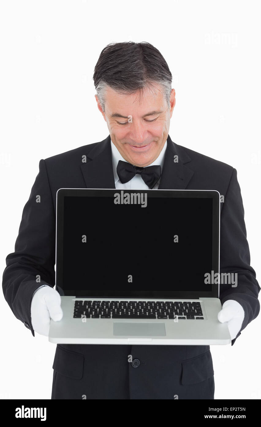 Happy waiter showing us something on a laptop Stock Photo - Alamy