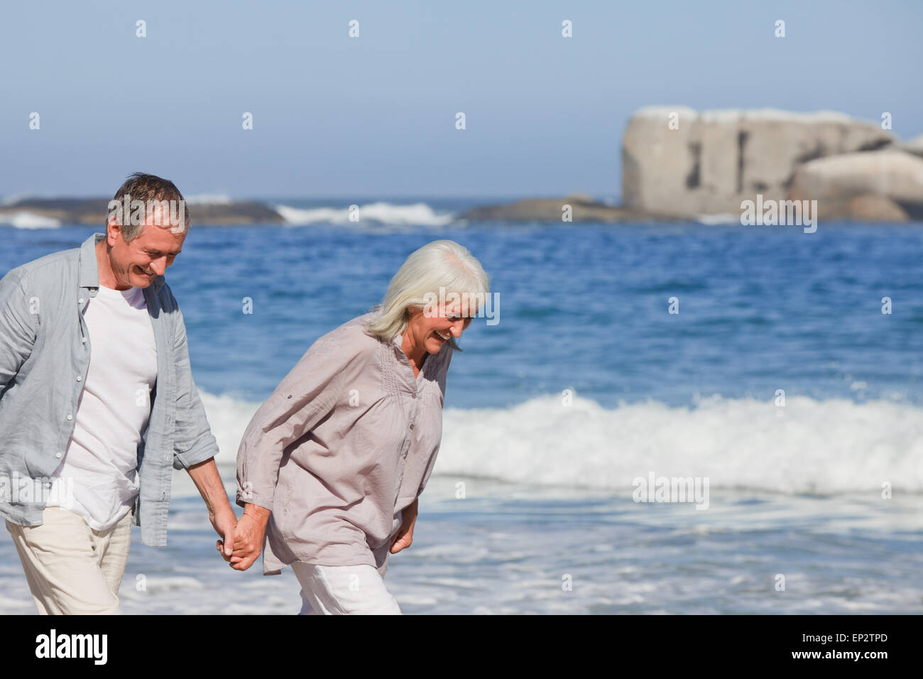 Elderly couple walking on the beach Stock Photo - Alamy