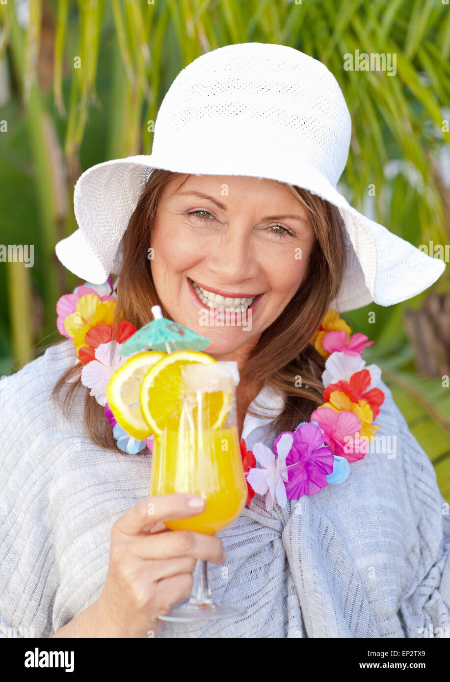 Retired woman drinking a cocktail under the sun Stock Photo - Alamy