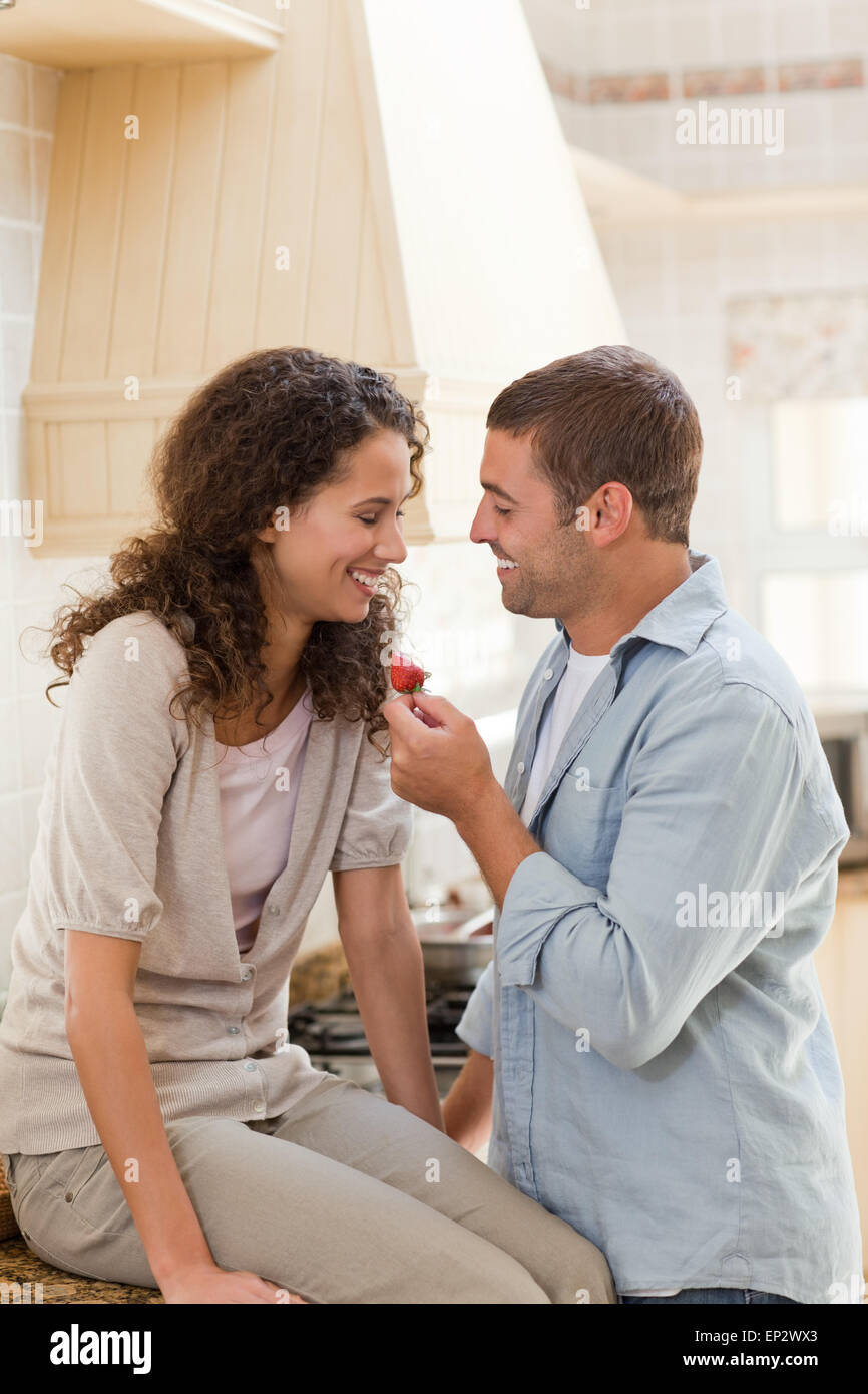 Lovers eating a strawberry in their kitchen Stock Photo - Alamy