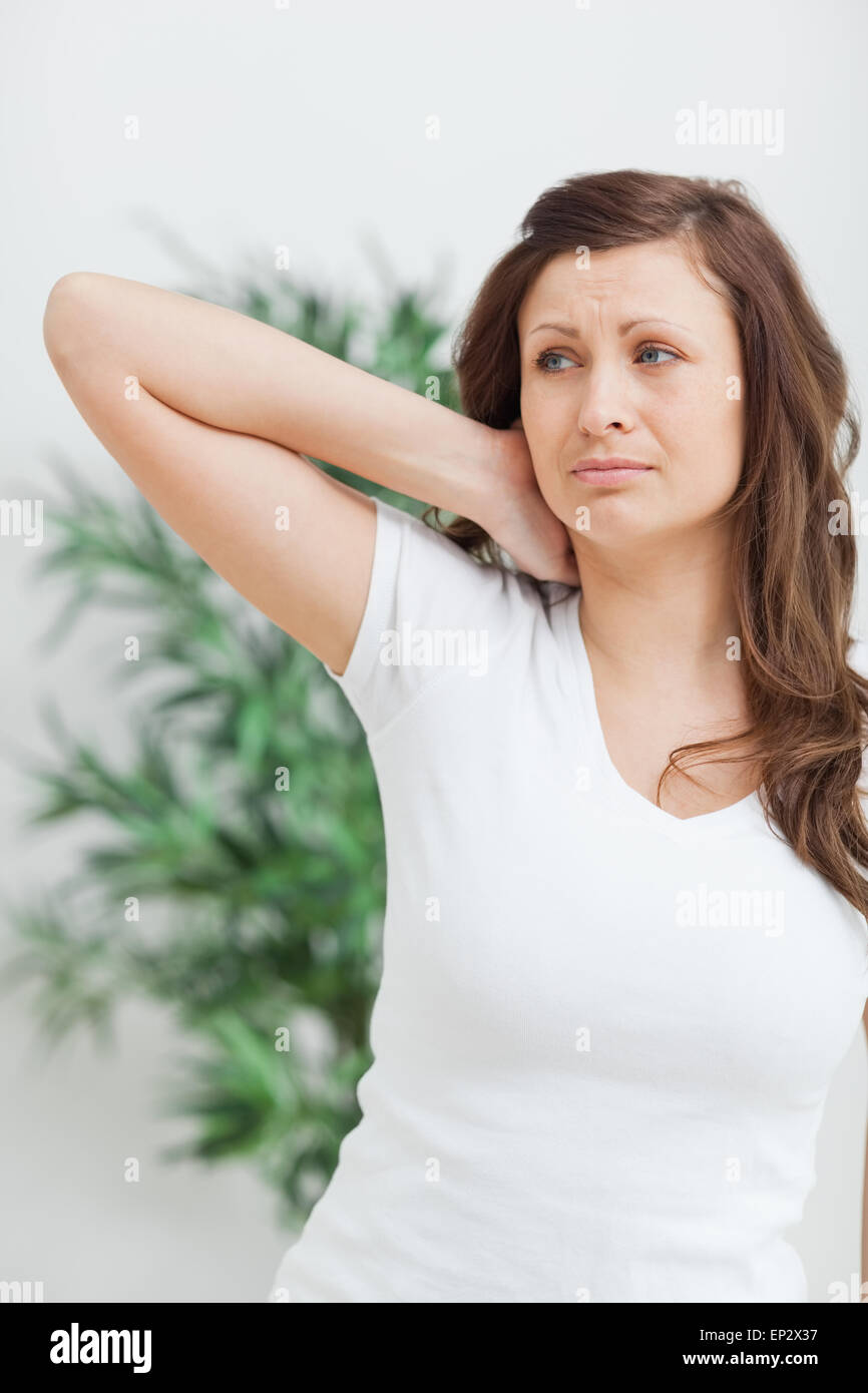 Woman standing while placing her hand on her neck Stock Photo - Alamy