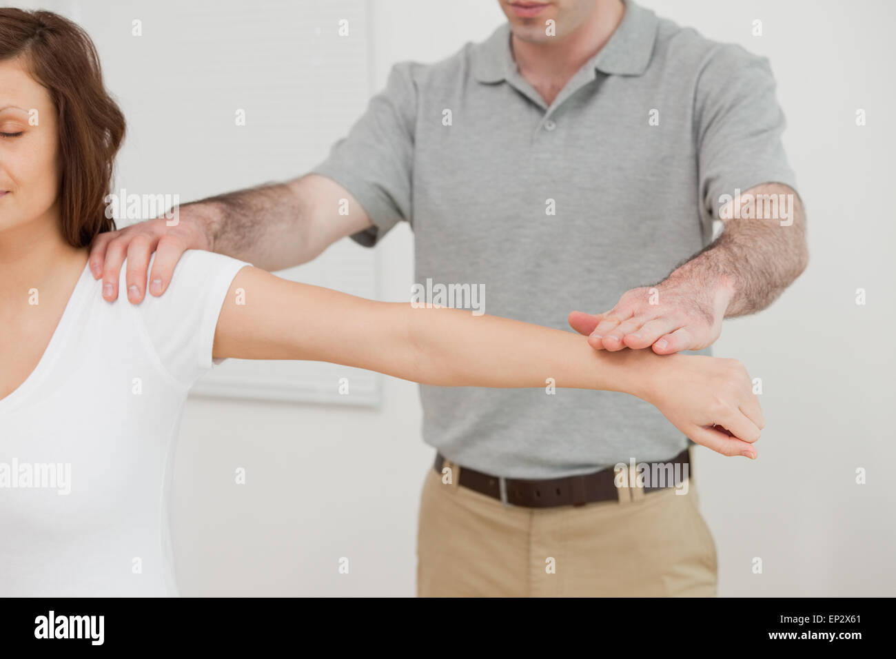 Woman sitting while a doctor is examining her arm Stock Photo - Alamy