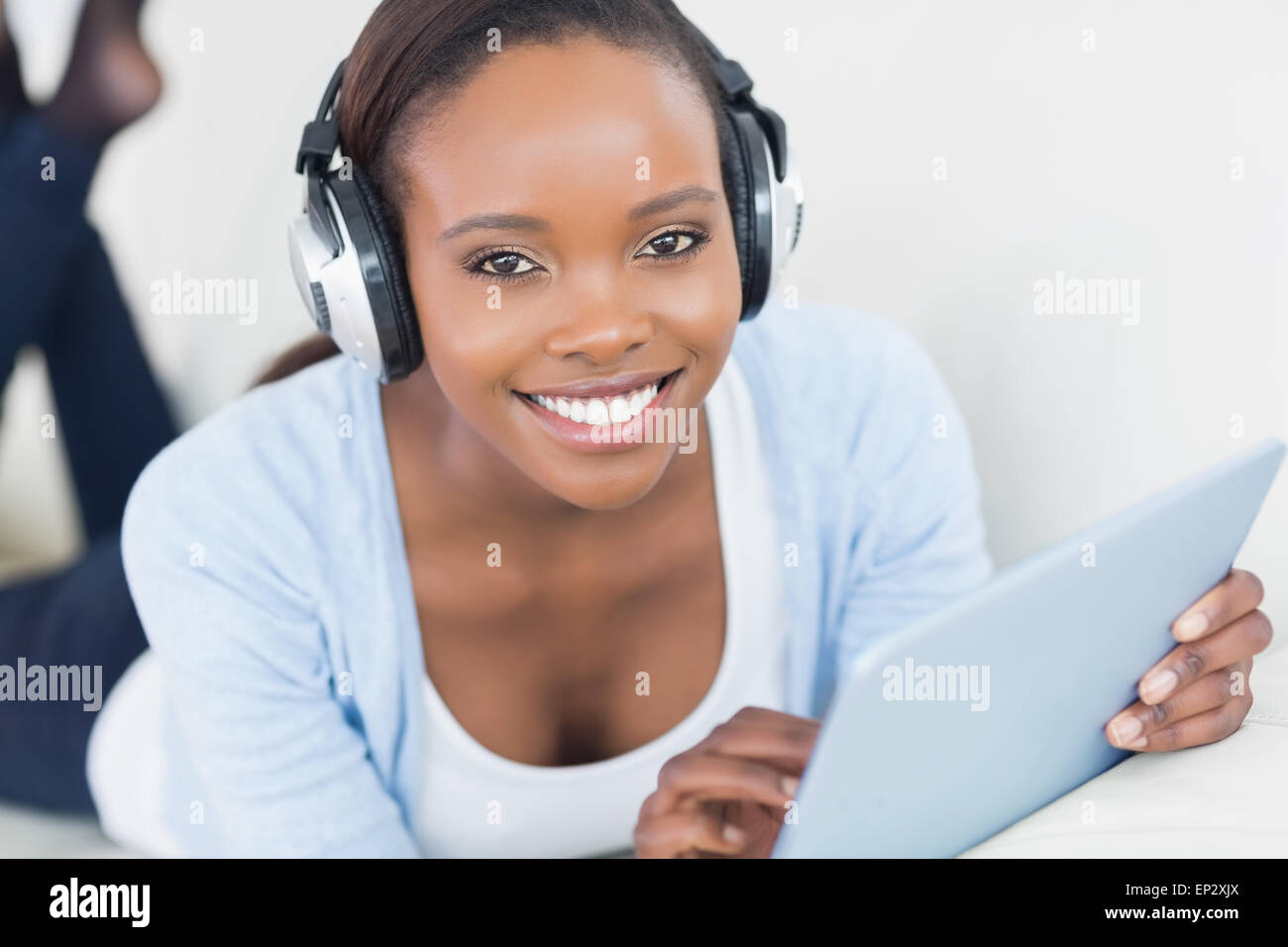 Black woman listening music while looking at camera Stock Photo - Alamy