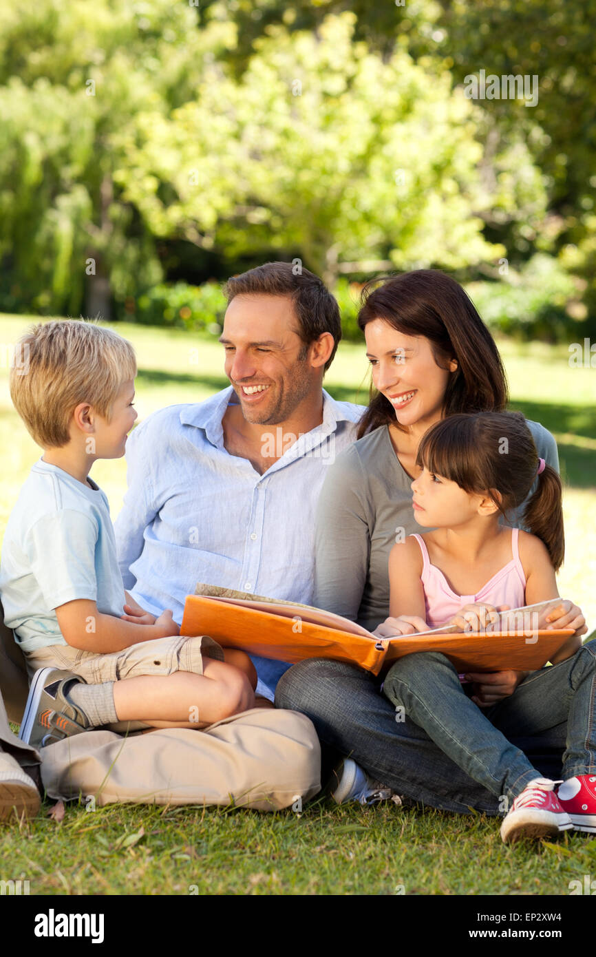 Family looking at their photo album in the park Stock Photo - Alamy