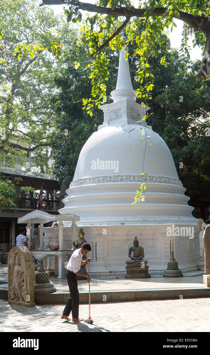 Young man sweeping Gangaramaya Buddhist Temple, Colombo, Sri Lanka ...