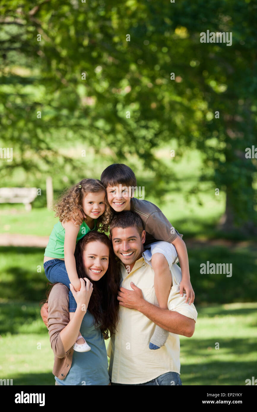 Parents giving children a piggyback Stock Photo - Alamy