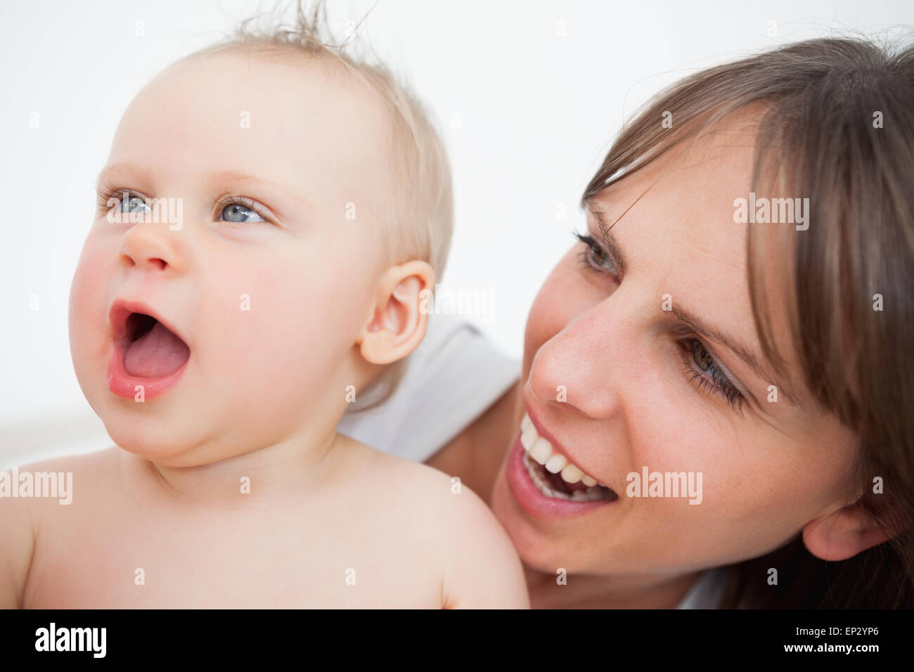 Cute baby opening her mouth while being held by her mother Stock Photo ...