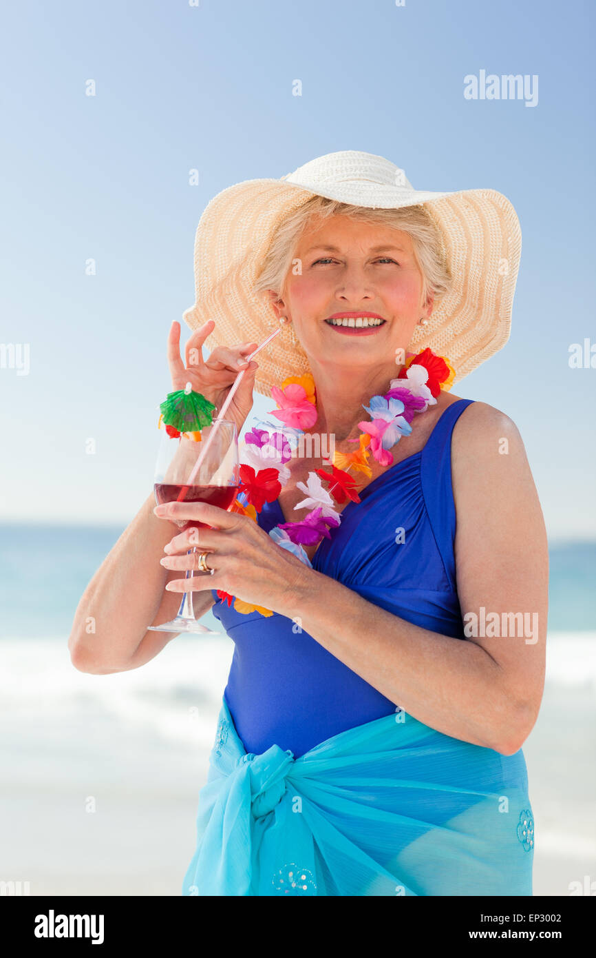Elderly woman drinking a cocktail on the beach Stock Photo - Alamy