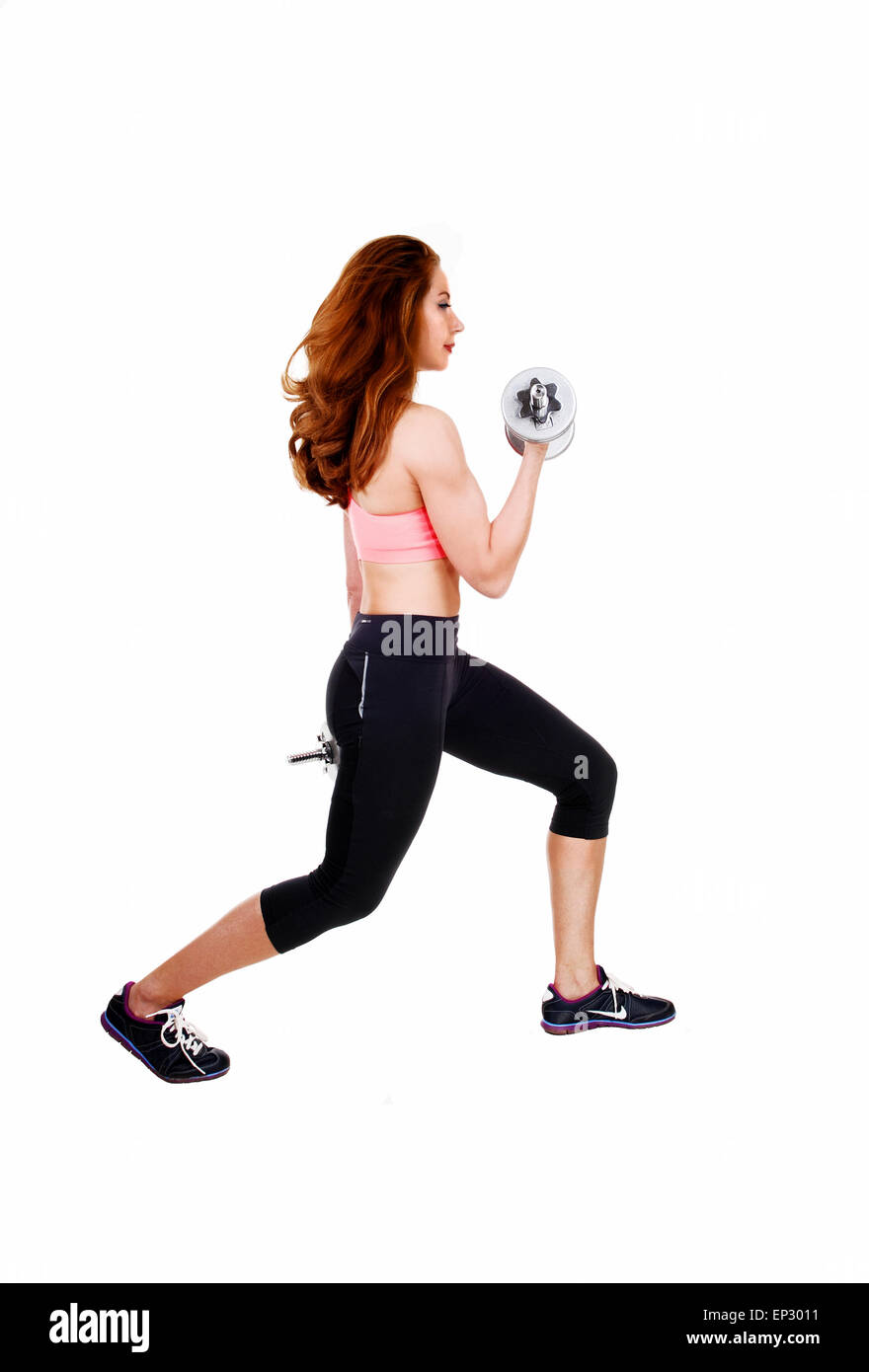 A lovely slim women in black exercise pants and sports bra working out ...