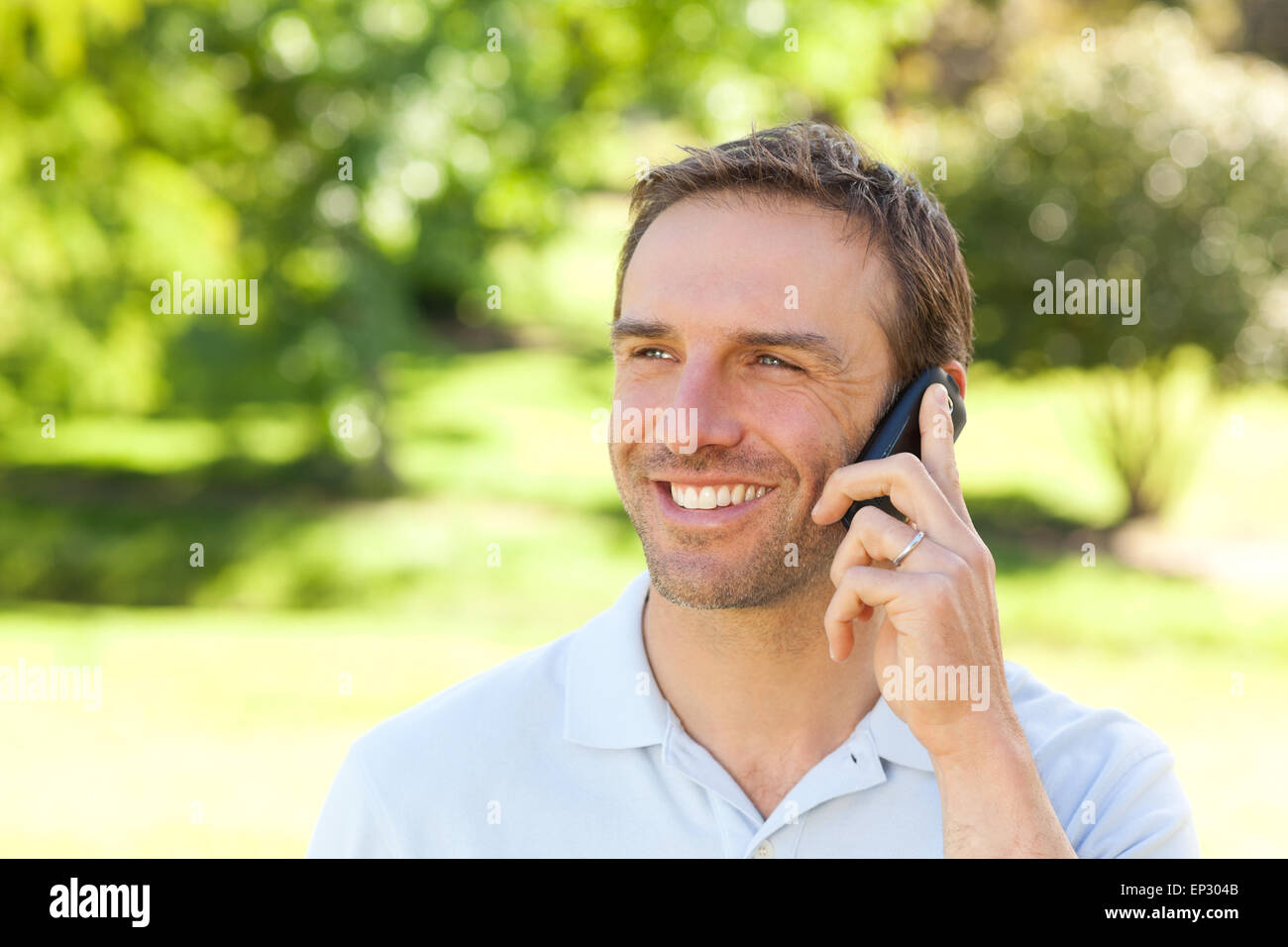 Handsome man phoning in the park Stock Photo - Alamy