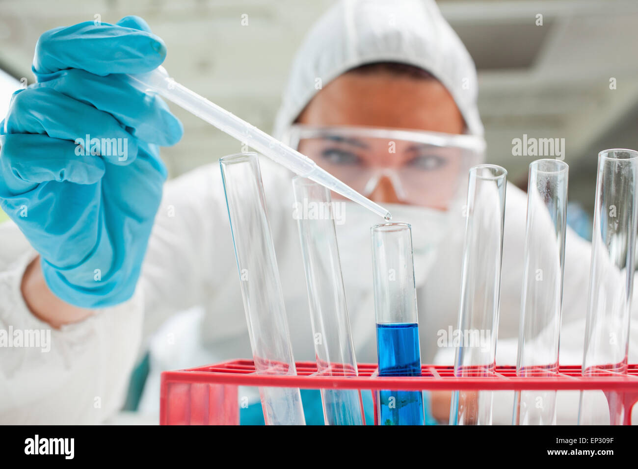 Close up of a protected scientist dropping liquid in a test tube Stock ...