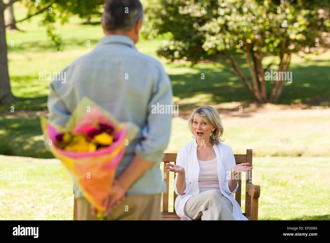 Mature man offering flowers to his wife Stock Photo - Alamy