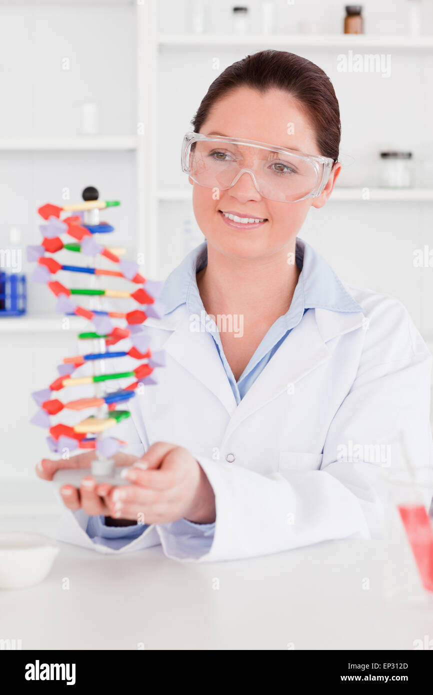 Cute scientist showing the dna double helix model Stock Photo - Alamy