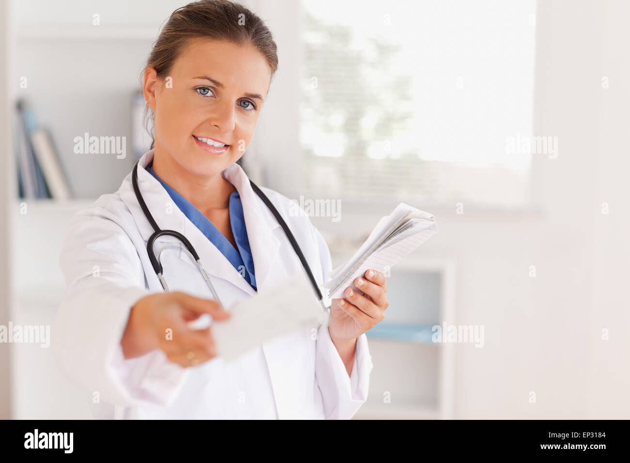 Charming brunette doctor handing out a prescription Stock Photo - Alamy