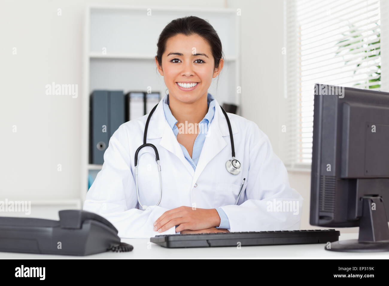 Pretty woman doctor with a stethoscope posing Stock Photo - Alamy