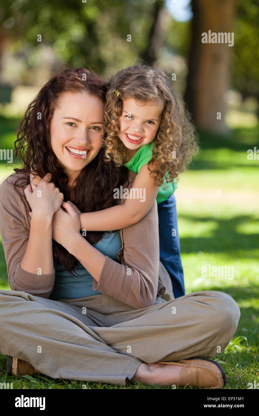 Woman hugging her daughter in the park Stock Photo - Alamy