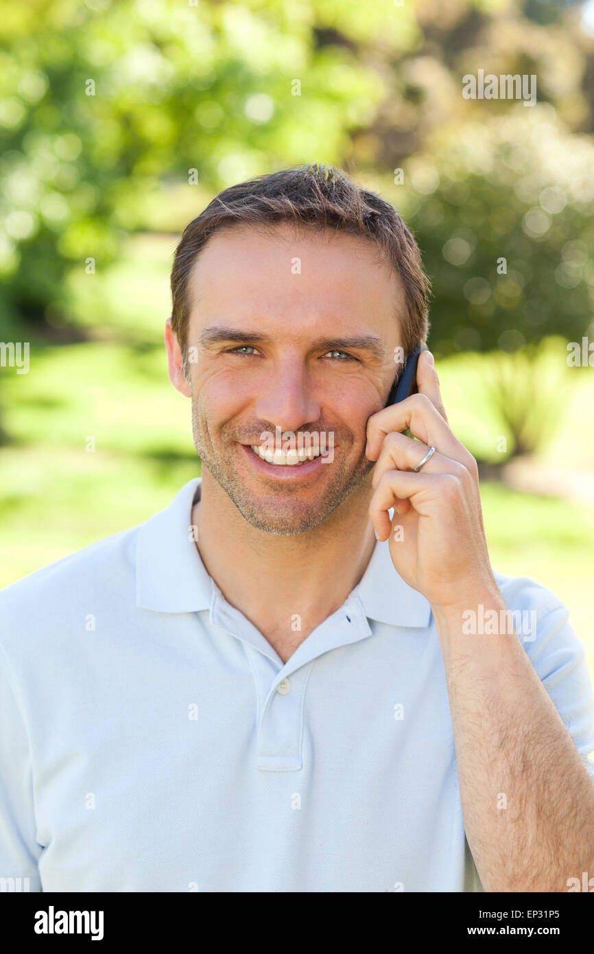 Handsome man phoning in the park Stock Photo - Alamy