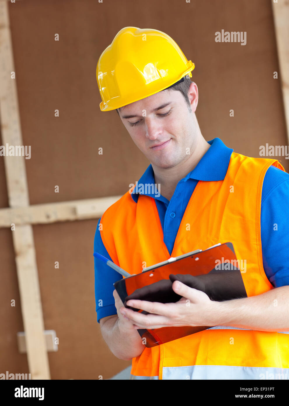 Handsome worker with hardhat taking notes on his clipboard Stock Photo ...