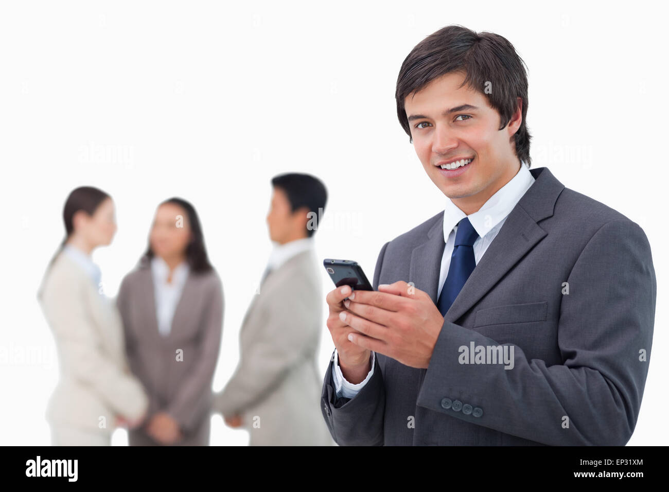 Salesman holding cellphone with team behind him Stock Photo - Alamy